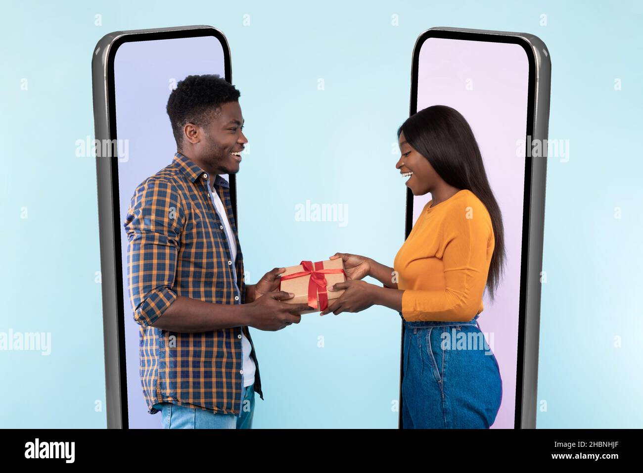 Couple exchanging presents from cell phone screens Stock Photo - Alamy