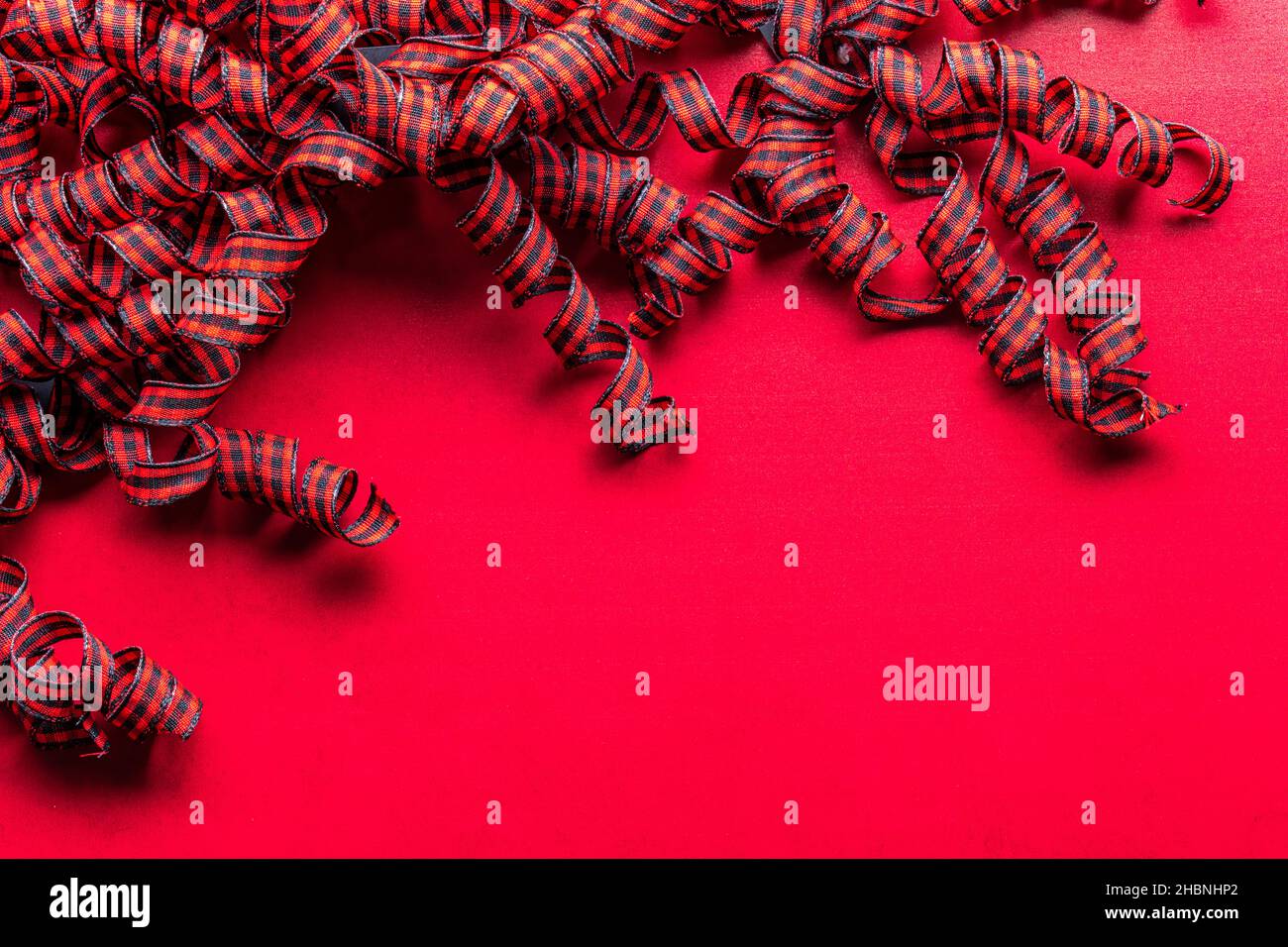 red and black plaid currled ribbons on a mottled red background Stock ...