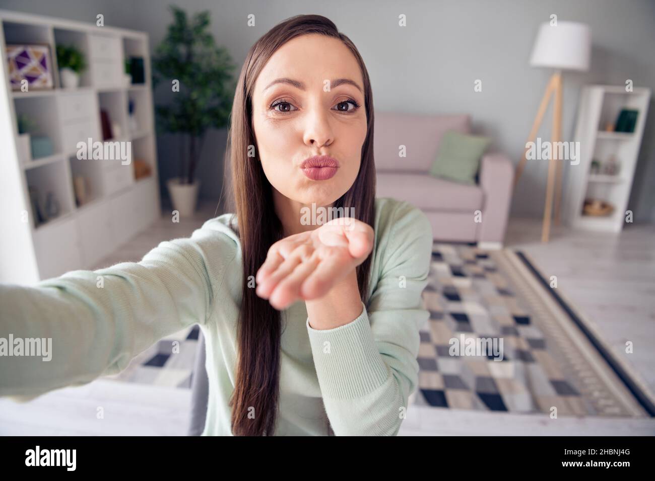 Self-portrait of attractive amorous woman staying safe sending air blow ...