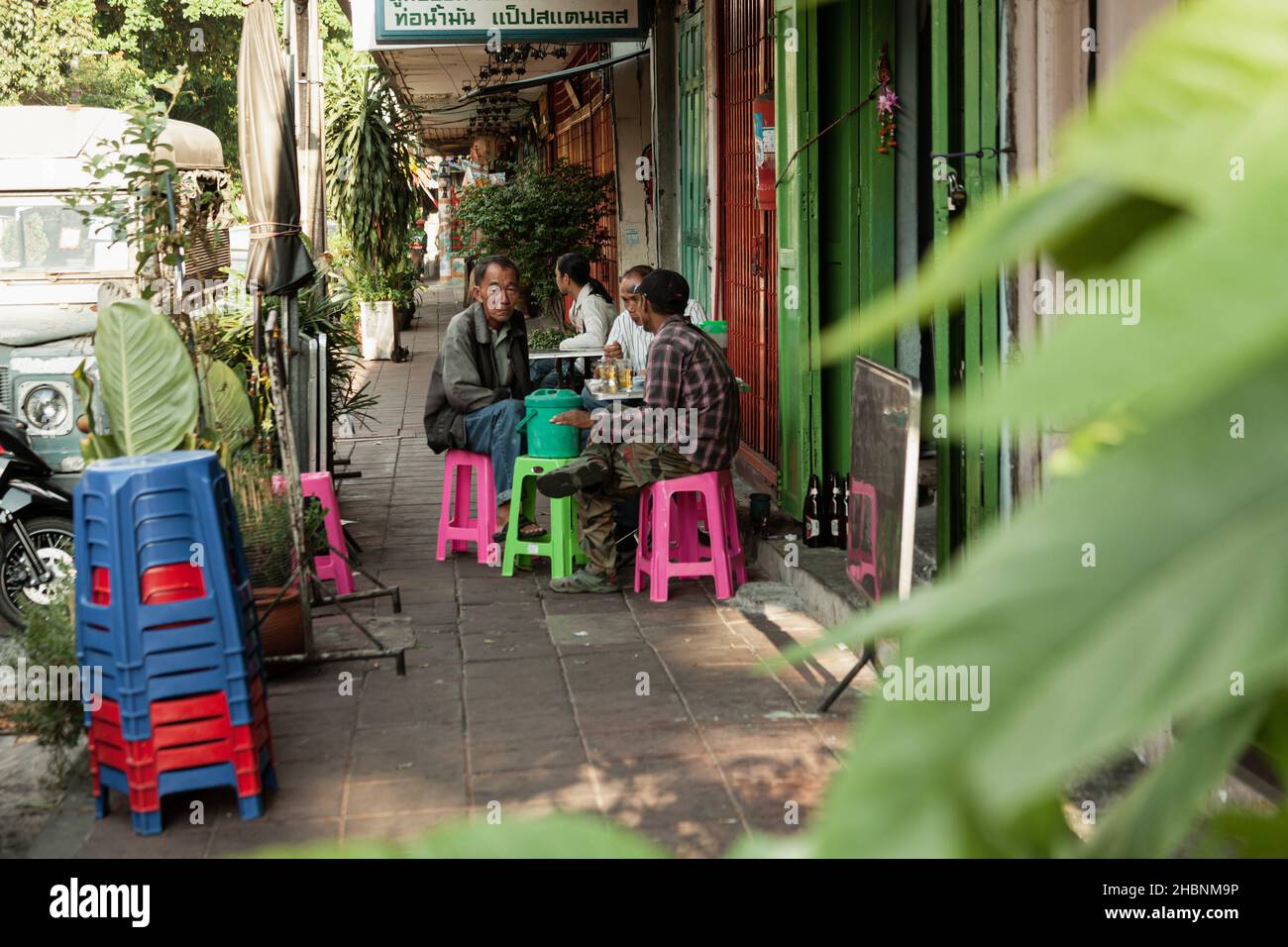 BANGKOK, THAILAND - MAY 3, 2014: Men having drinks in the roadside cafe ...