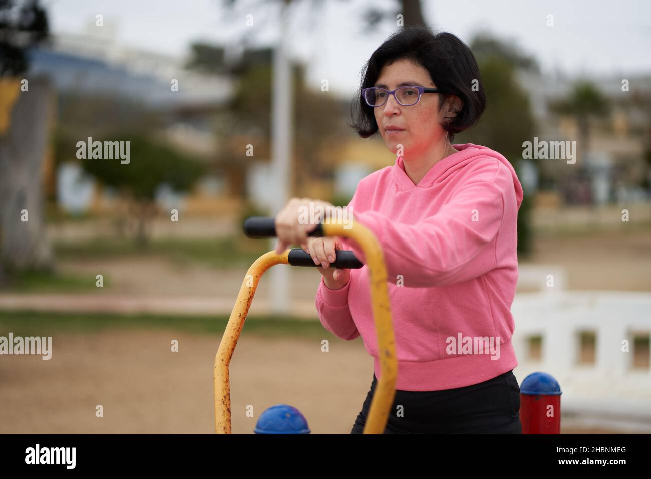 Short-haired woman exercises on square machines Stock Photo - Alamy