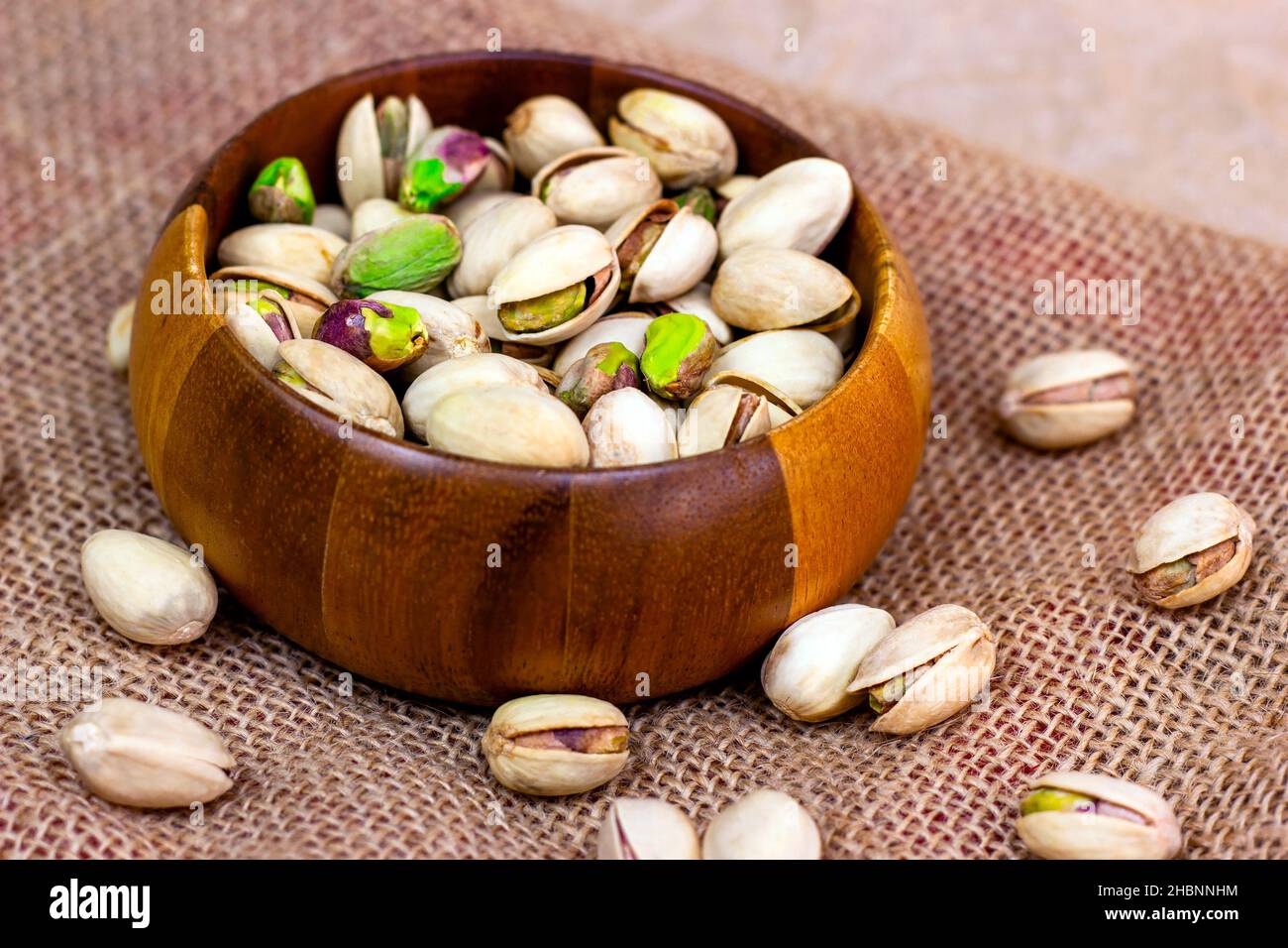 Roasted salted pistachio nuts in nutshell in wooden bowl on textured background Stock Photo - Alamy