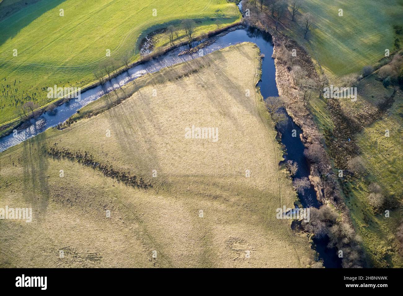 Aerial view of river and empty green meadow field Stock Photo - Alamy