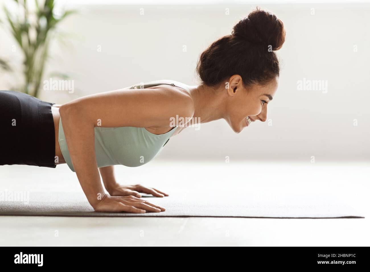 Side View Of Young Woman Doing Plank Exercise And Push Ups Indoors ...