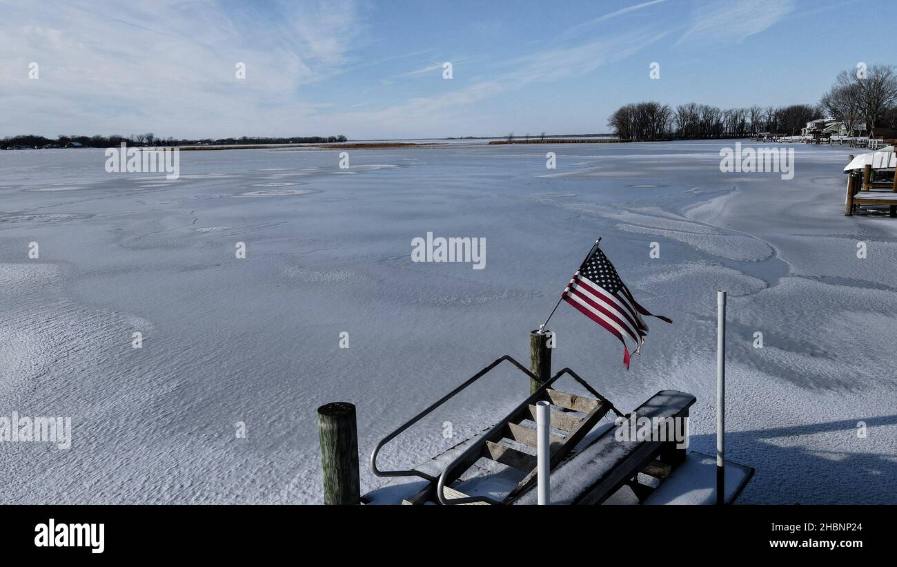 View from the dock of frozen lake Winneconne with American flag in the ...