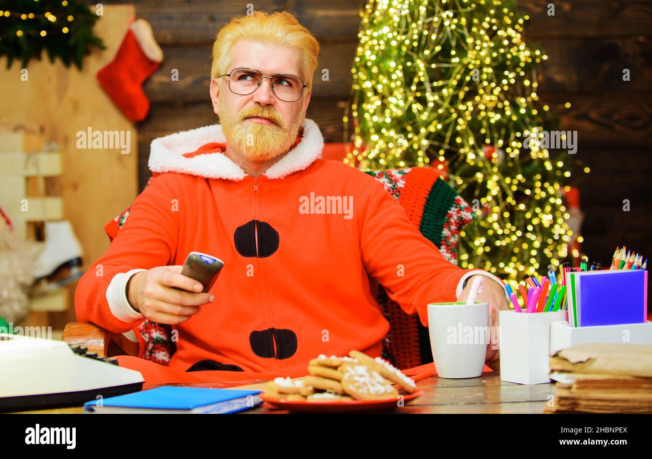 Thoughtful Santa Claus watching Christmas movie sit at table with ...