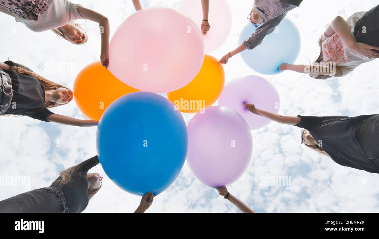 Friendly girls release big balloons together in the park Stock Photo ...