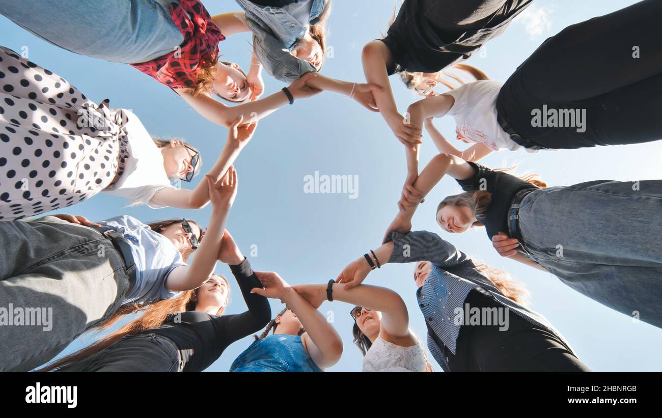 A group of girls makes a circle shape holding each other's hands Stock ...