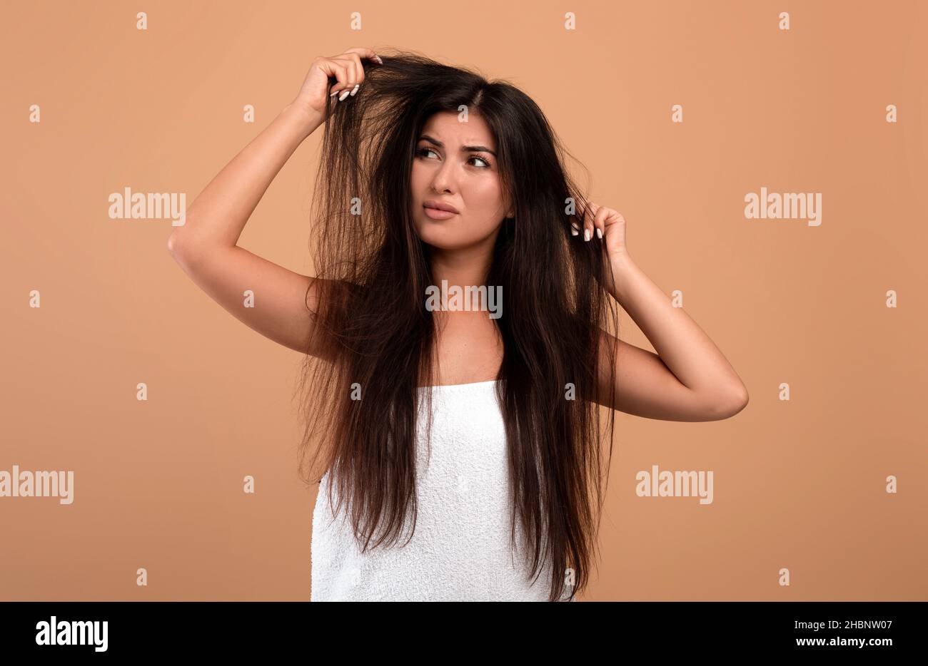 Frustrated armenian woman showing her damaged long locks, having bad ...