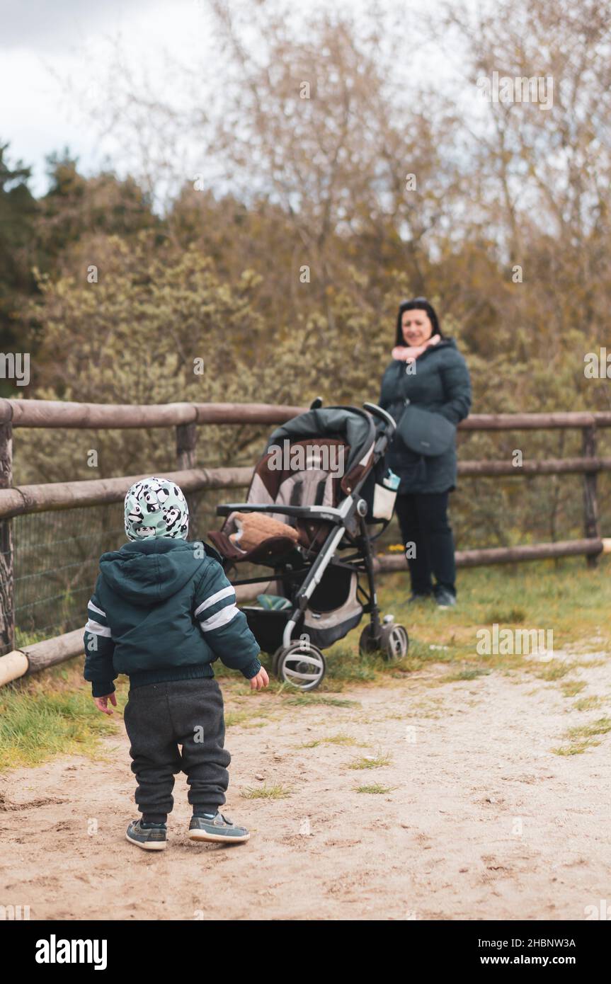 POZNAN, POLAND - May 05, 2019: A woman with a buggy and child standing ...