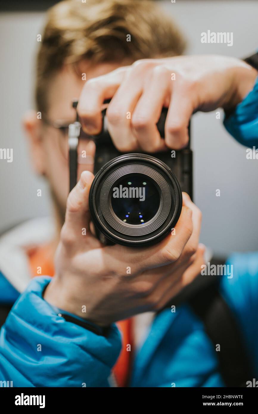 A vertical shot of a photographer holding a camera Stock Photo - Alamy