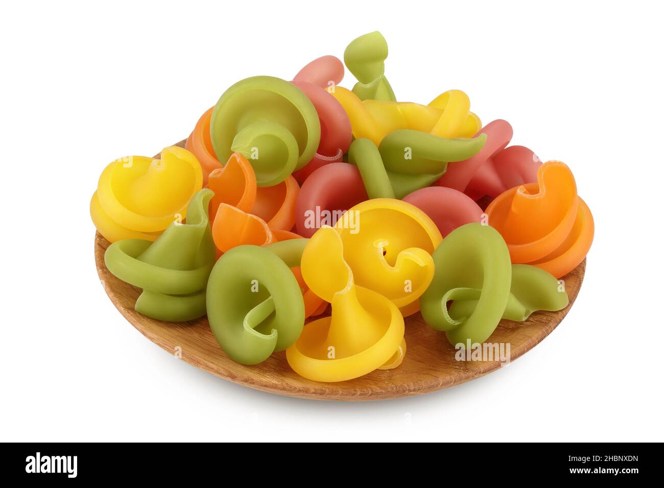 Raw colored pasta in wooden bowl isolated on white background with ...