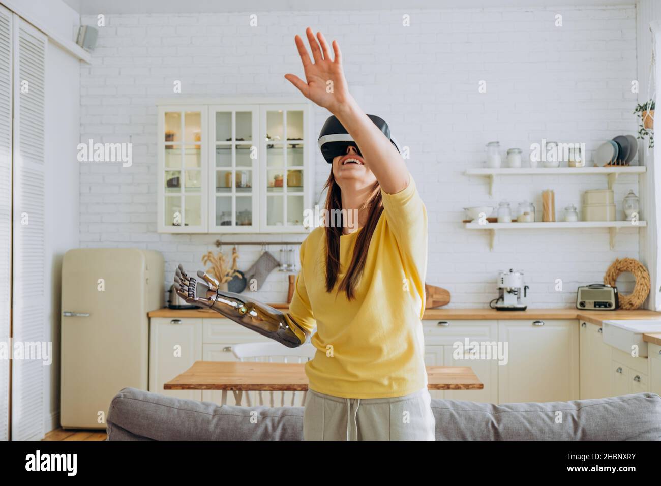 Positive young woman in casual clothes with modern bionic arm and ...