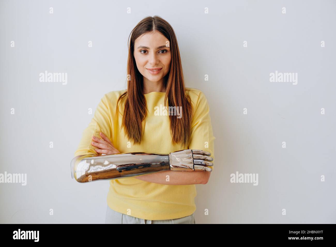 Pretty smiling blonde young woman with elegant bionic prosthesis arm ...