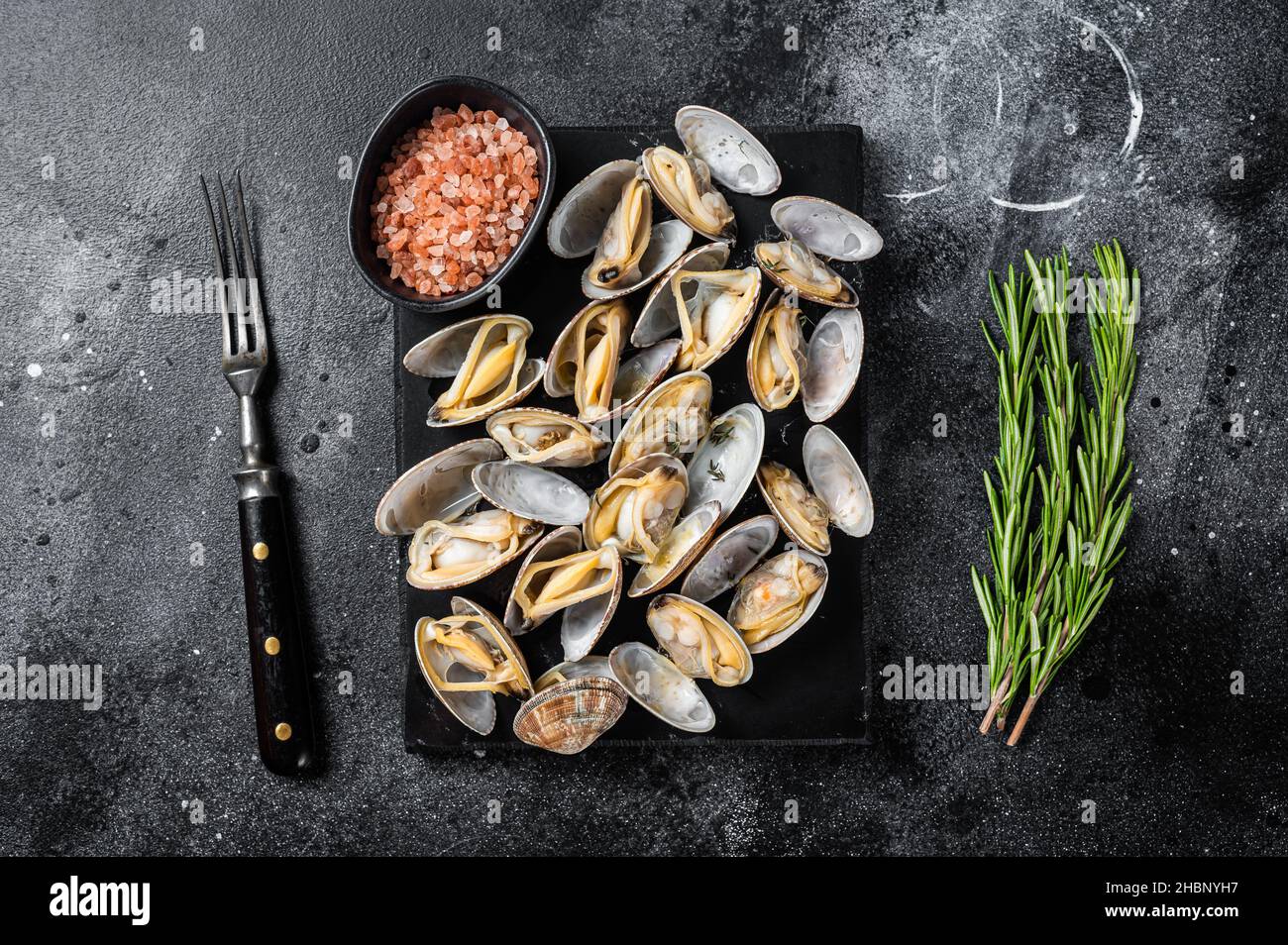 Steamed shellfish Clams with garlic and herbs. Black background. Top ...