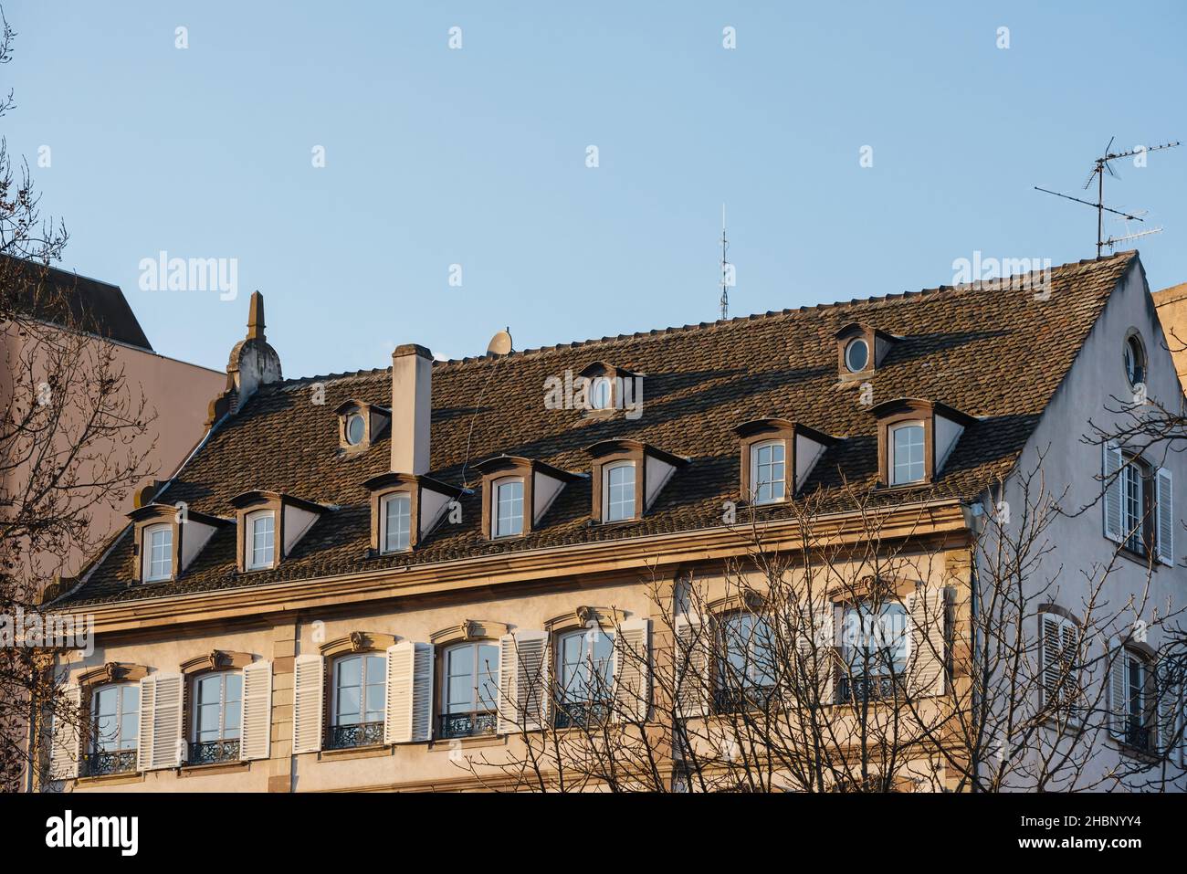 traditional French apartment building with balconies and clear blue sky ...