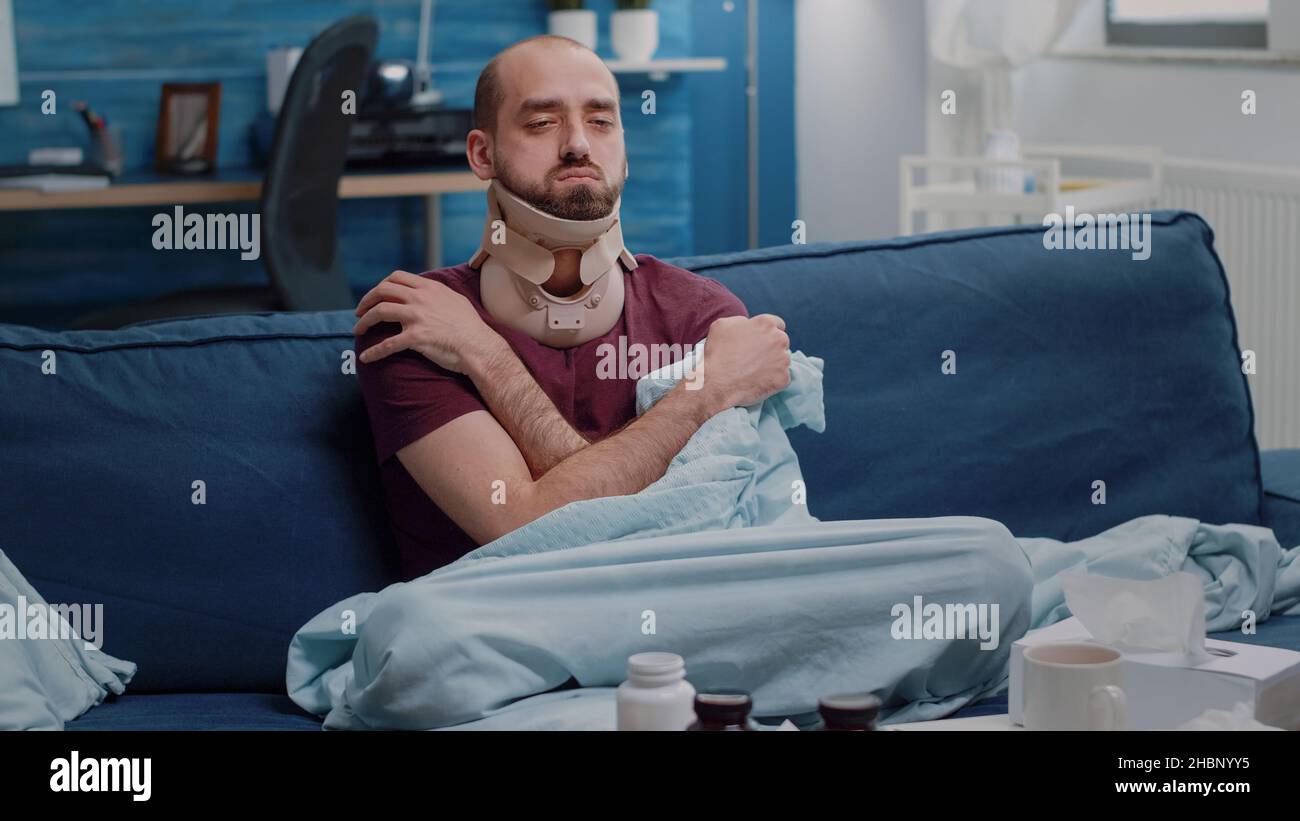 Unwell adult with cervical collar healing muscle injury and shivering ...