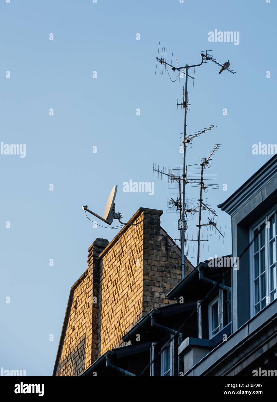 Large satellite communication dish on the rooftop of apartment building ...