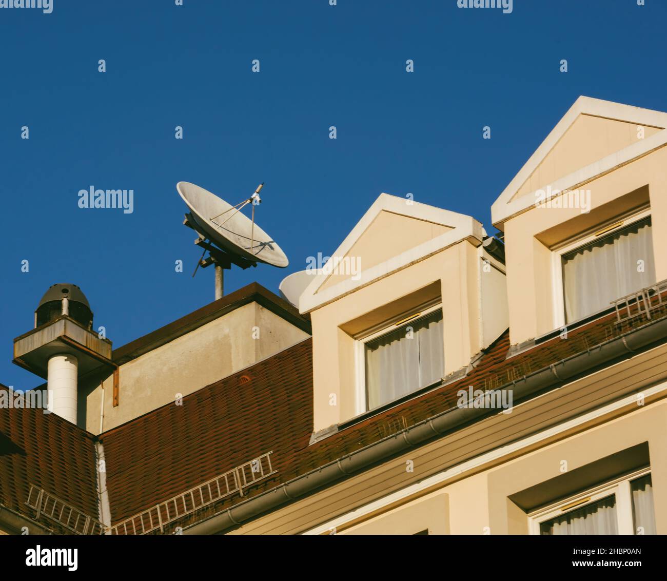 Large satellite communication dish on the rooftop of apartment building ...