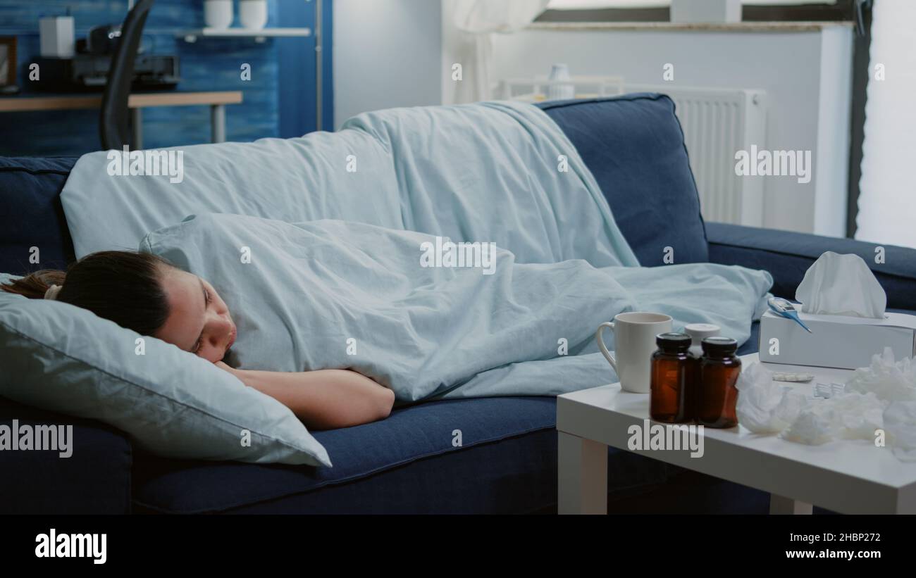Sick woman laying on couch with blanket feeling cold and having virus ...