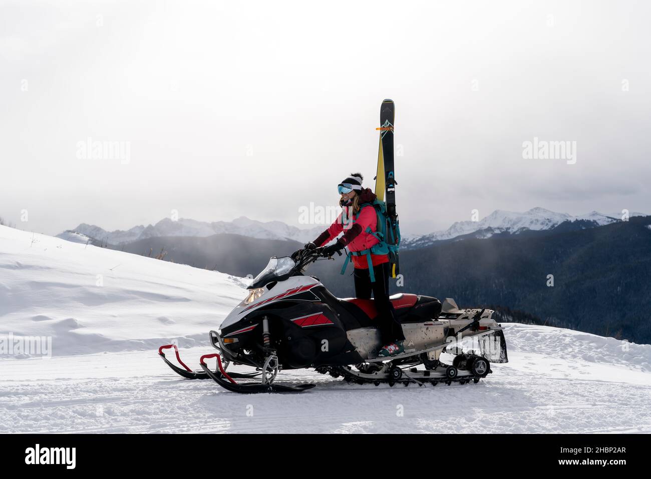 Adventurous woman riding snowmobile in winter Stock Photo - Alamy