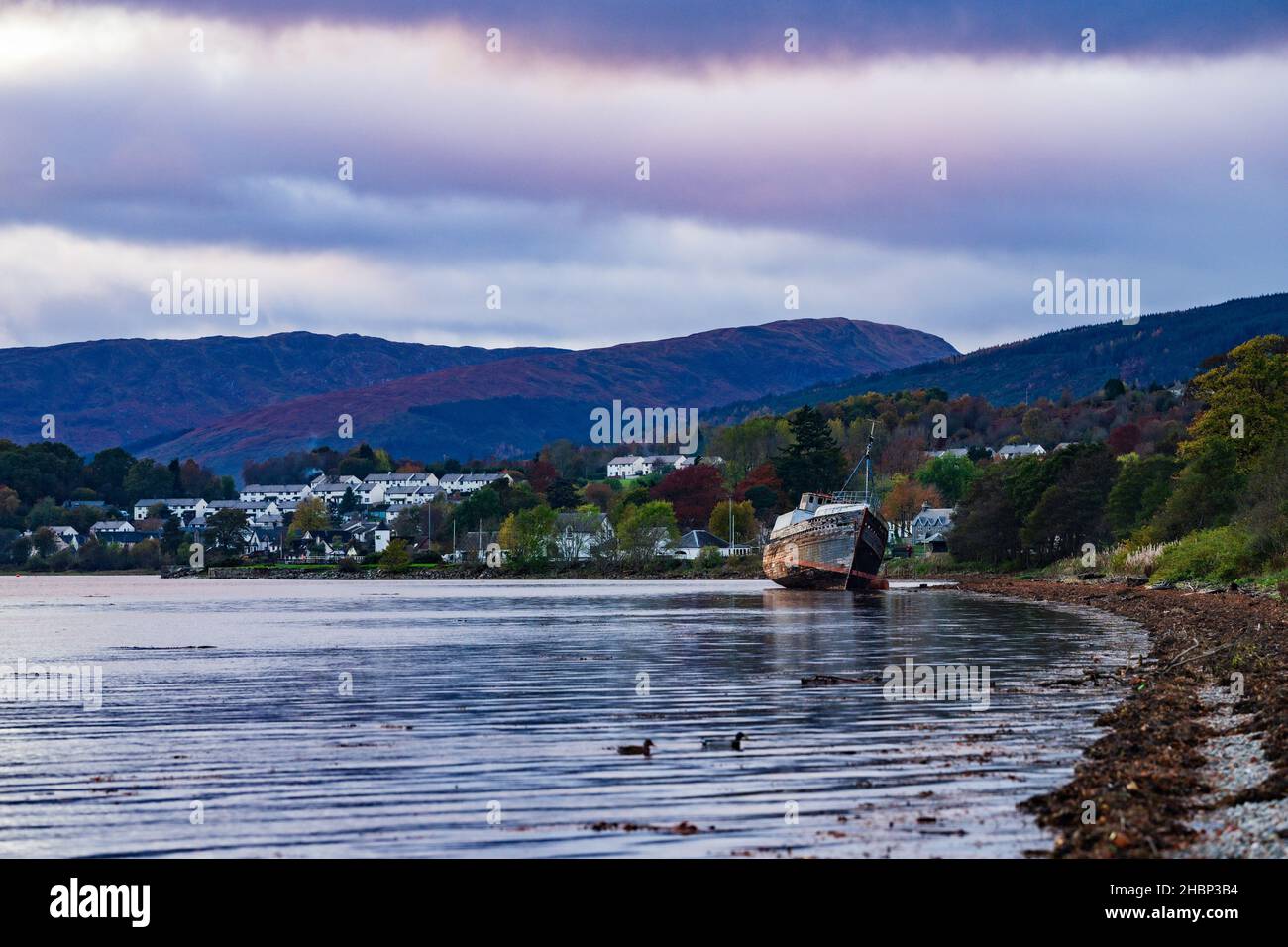 A grounded fishing boat on a beach at Loch Linnhe, with Ben Nevis in ...
