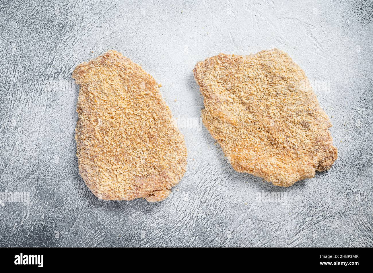 Raw chicken schnitzel Escalope in breadcrumbs. White background. Top ...