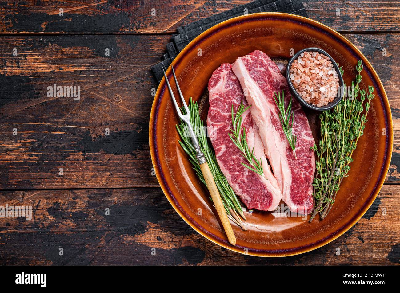 Two sliced Raw Striploin steaks or New York steaks, beef meat. Dark ...