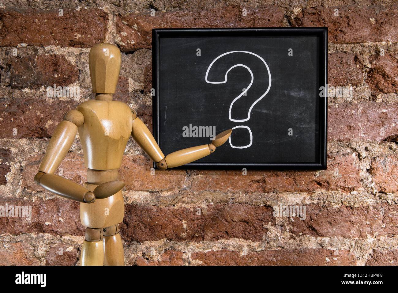 A wooden mannequin showing a question mark on chalkboard, blackboard ...
