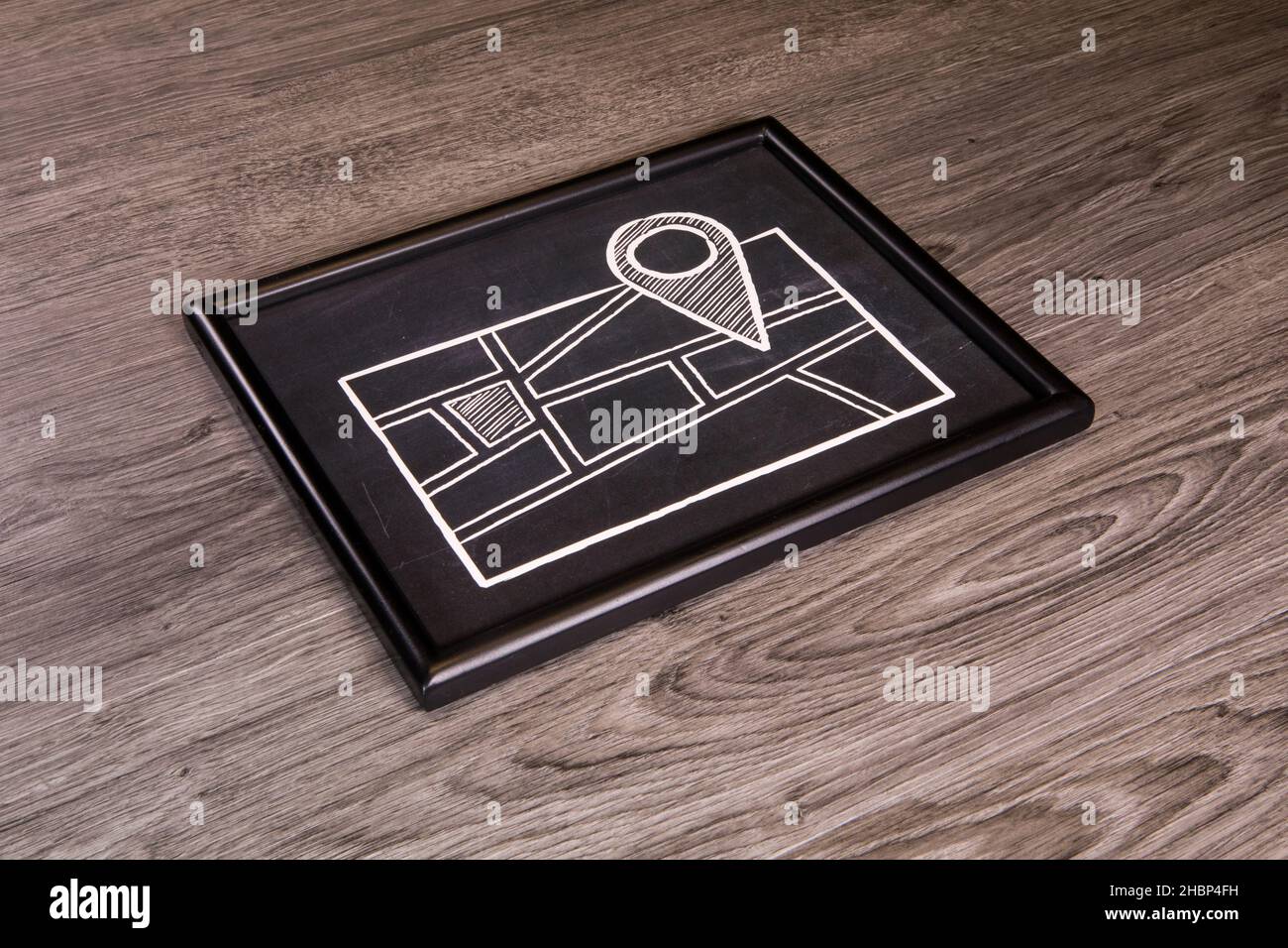 A location map on chalkboard, blackboard over a gray wood background ...