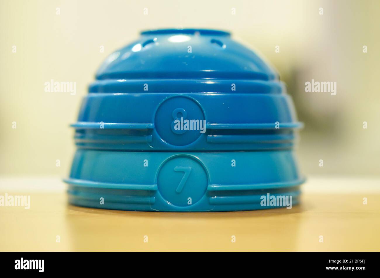 A closeup of child's blue stacking toy bowls on the wooden table Stock ...