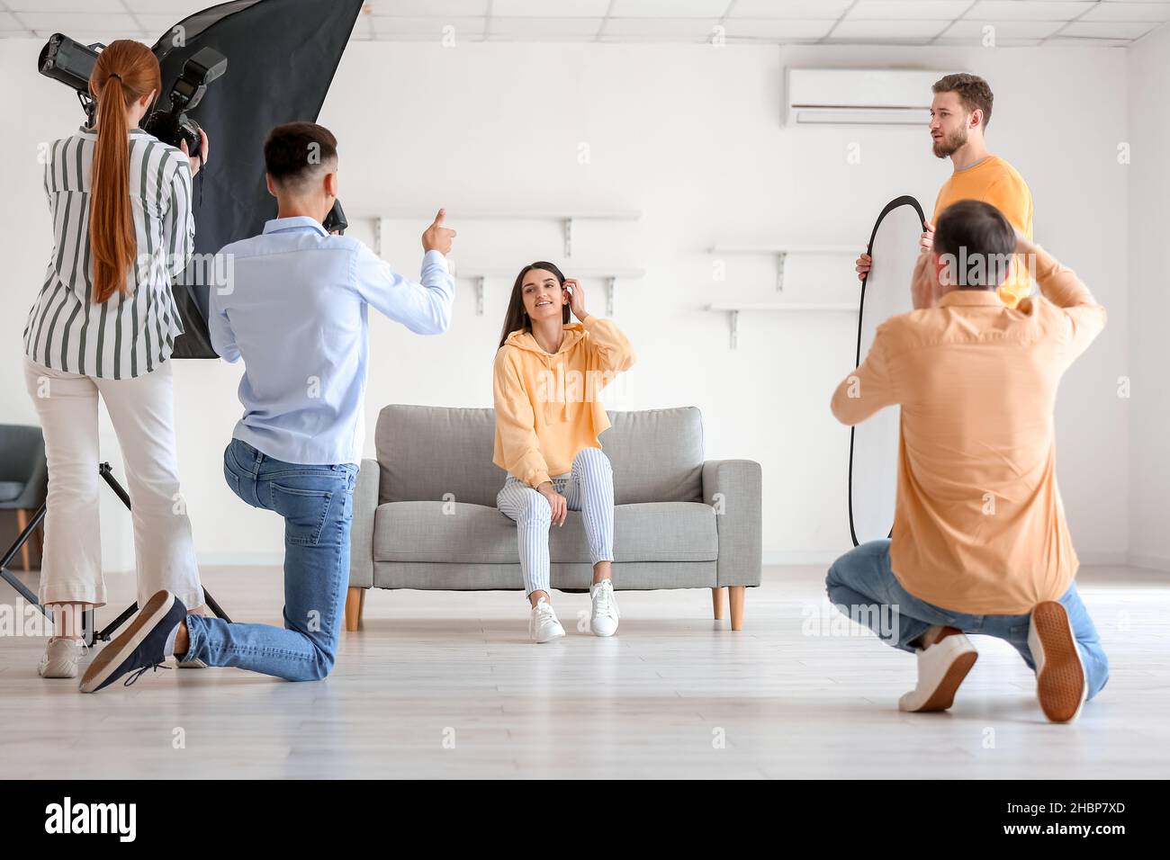 Young photographers taking picture of model in studio Stock Photo - Alamy