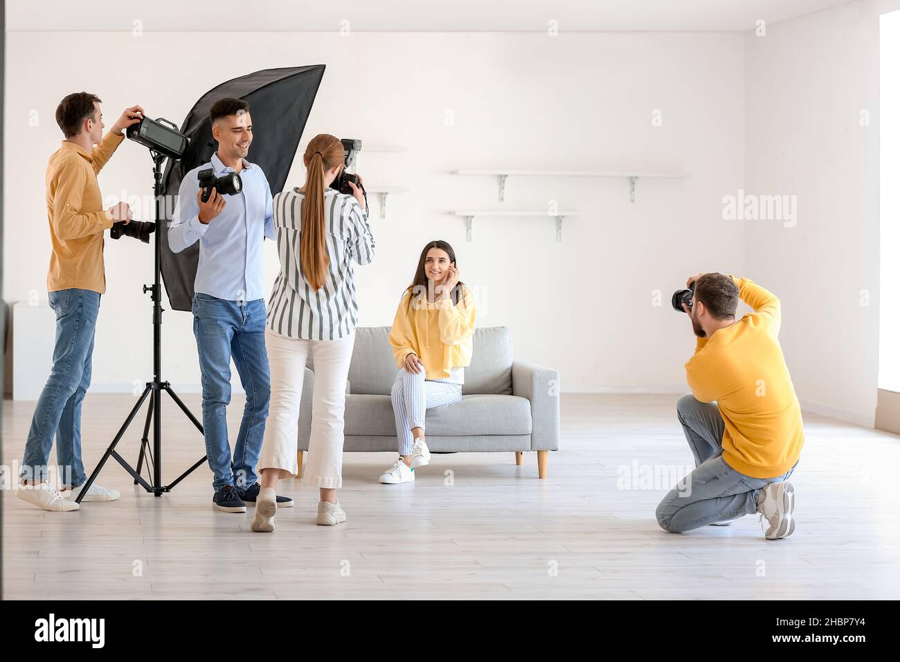 Young photographers taking picture of model in studio Stock Photo - Alamy