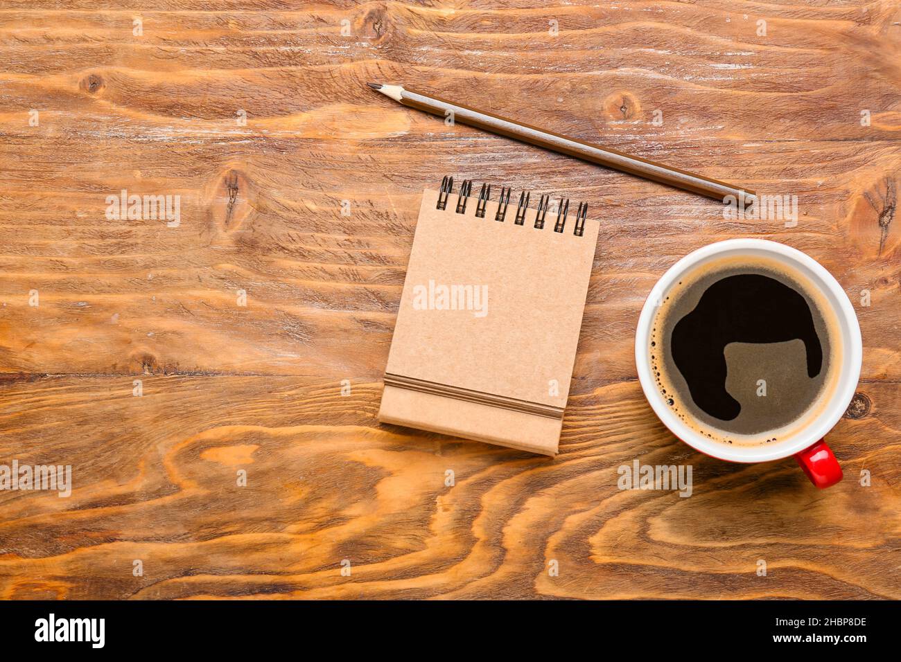 Blank craft calendar, pencil and cup of coffee on wooden background ...