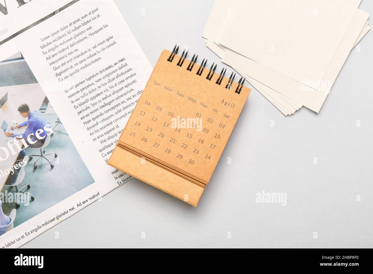 Craft calendar, sticky notes and newspaper on grey background, closeup ...