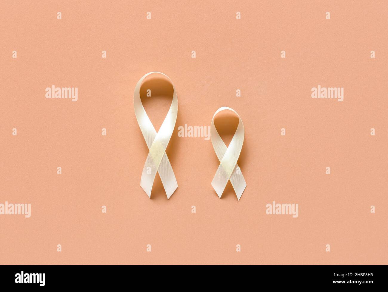 White awareness ribbons on color background. World Cancer Day Stock ...