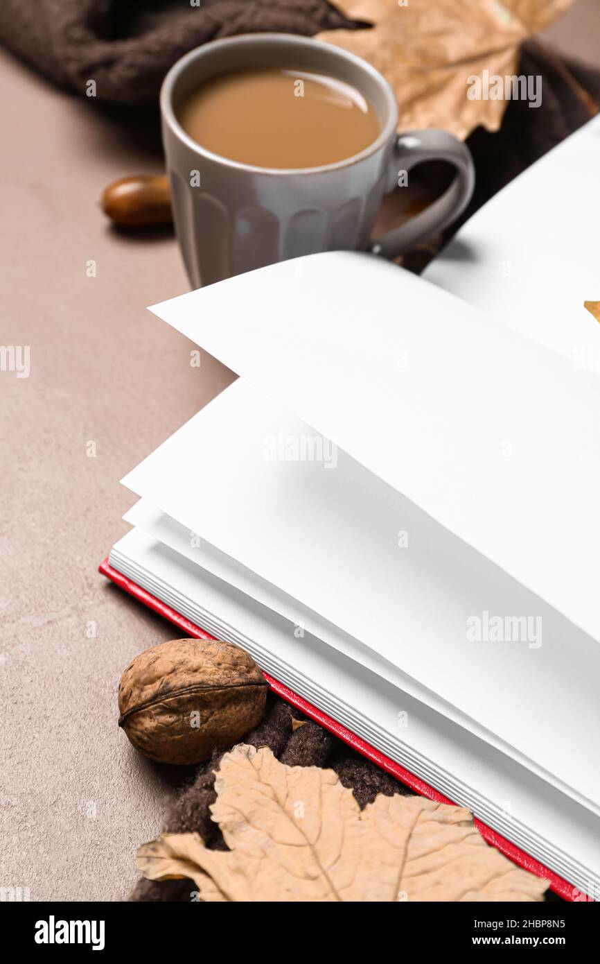 Cup of tasty coffee, blank book and autumn leaves on beige background ...