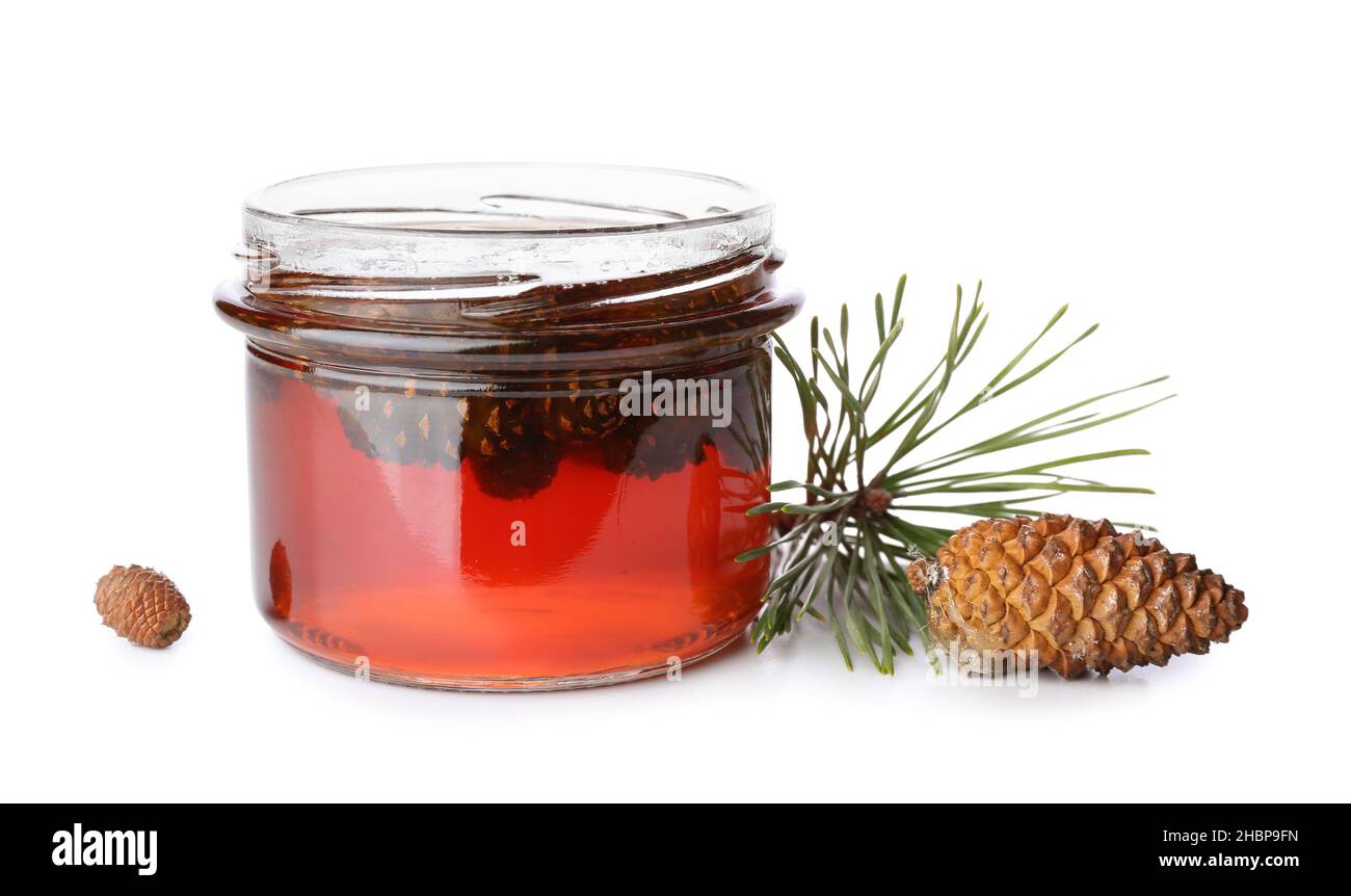 Jar of tasty pine cone jam and fir tree branch on white background ...