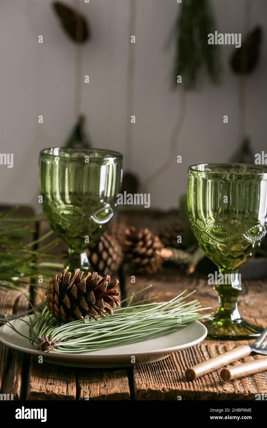 Beautiful table setting with pine cones and fir branches indoors Stock ...