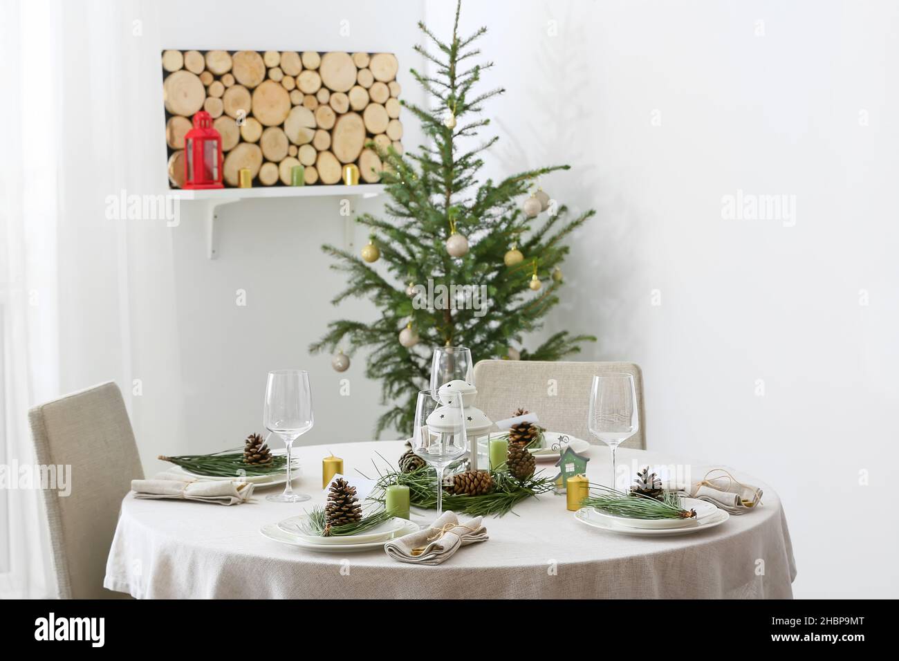 Beautiful table setting with pine cones and fir branches in room ...