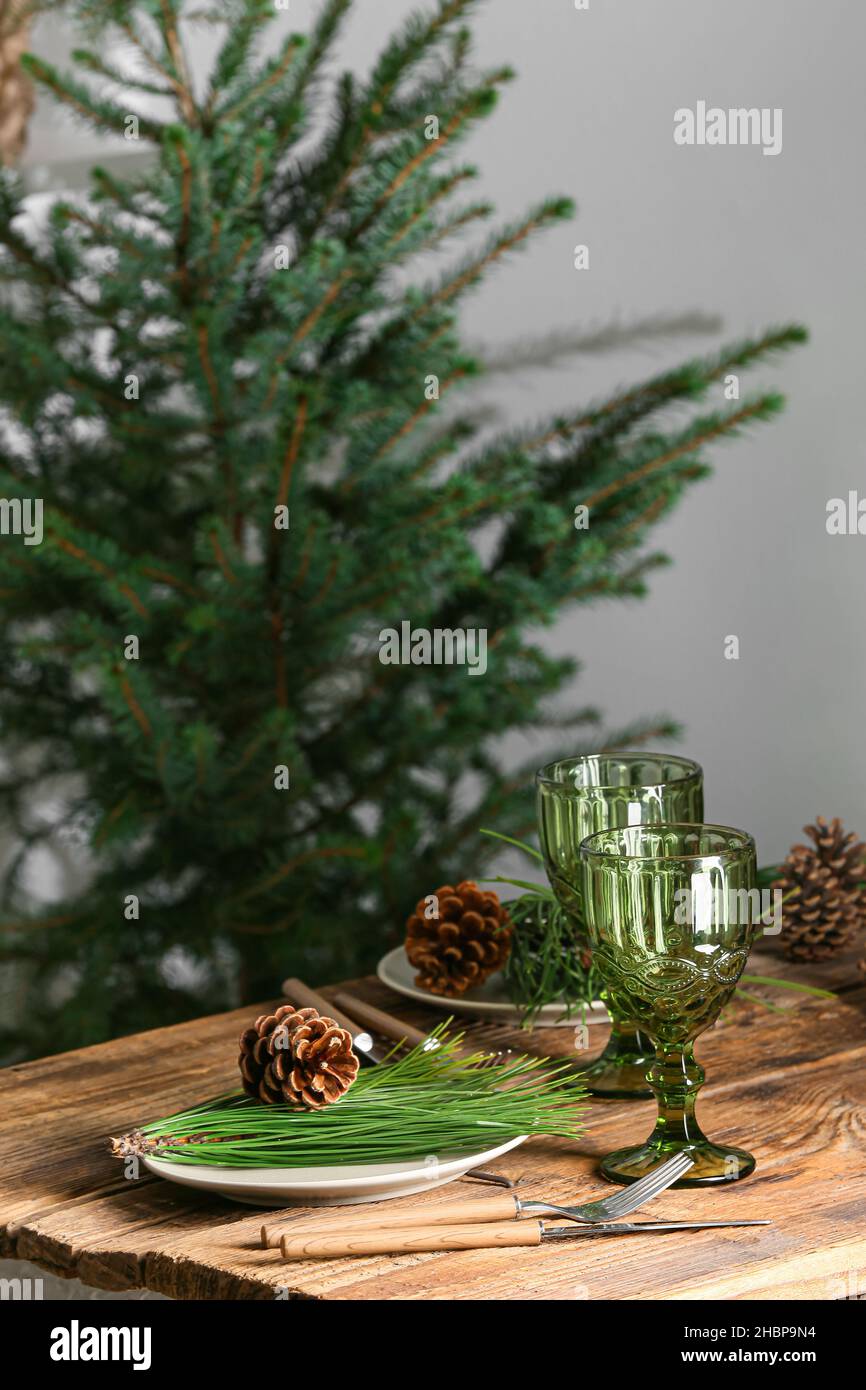 Beautiful table setting with pine cones and fir branches indoors Stock ...