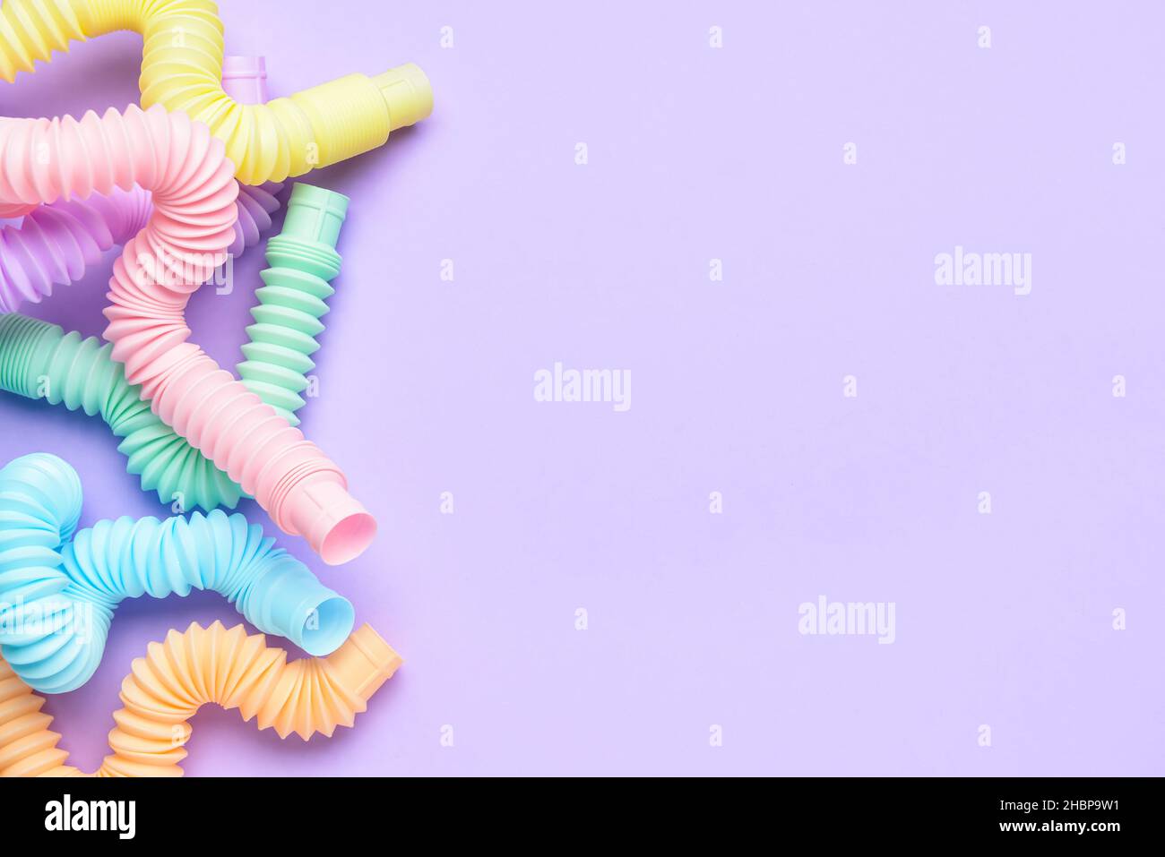 Different colorful Pop Tubes on purple background Stock Photo - Alamy