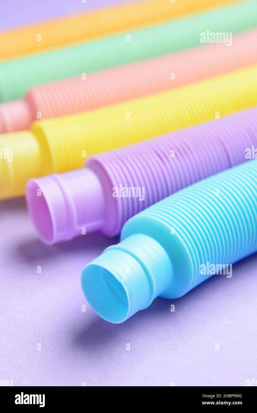 Different colorful Pop Tubes on purple background, closeup Stock Photo ...