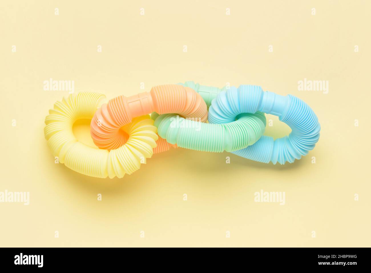 Different colorful Pop Tubes on beige background Stock Photo - Alamy