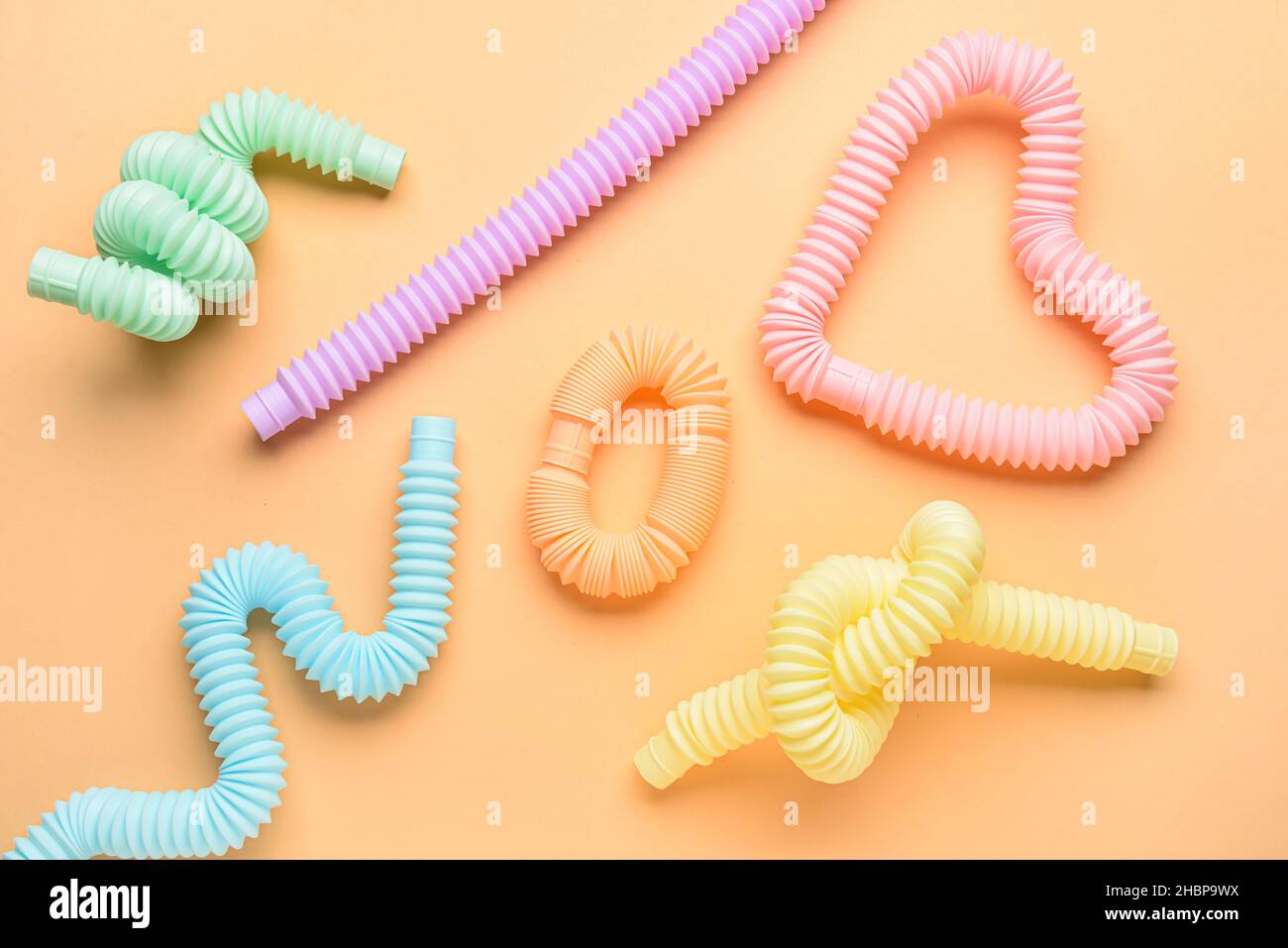 Different colorful Pop Tubes on orange background Stock Photo - Alamy