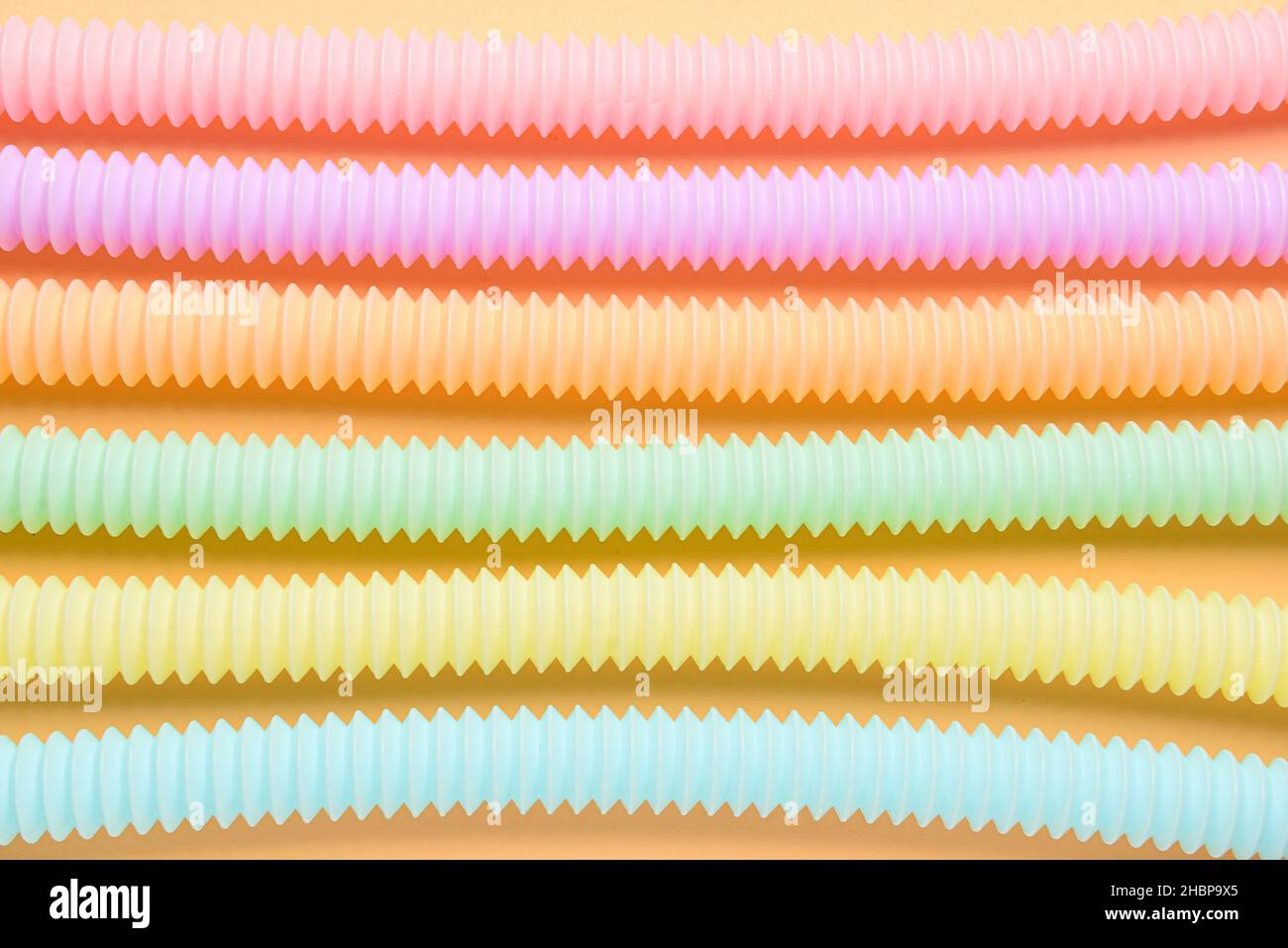 Different colorful Pop Tubes on color background Stock Photo - Alamy