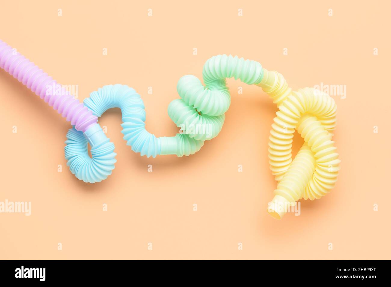 Different colorful Pop Tubes on orange background Stock Photo - Alamy