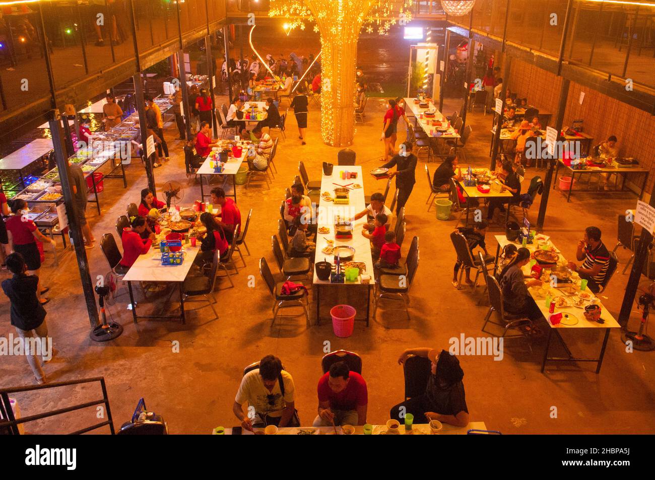 an open-air seafood BBQ restaurant with Cambodians cooking at their ...