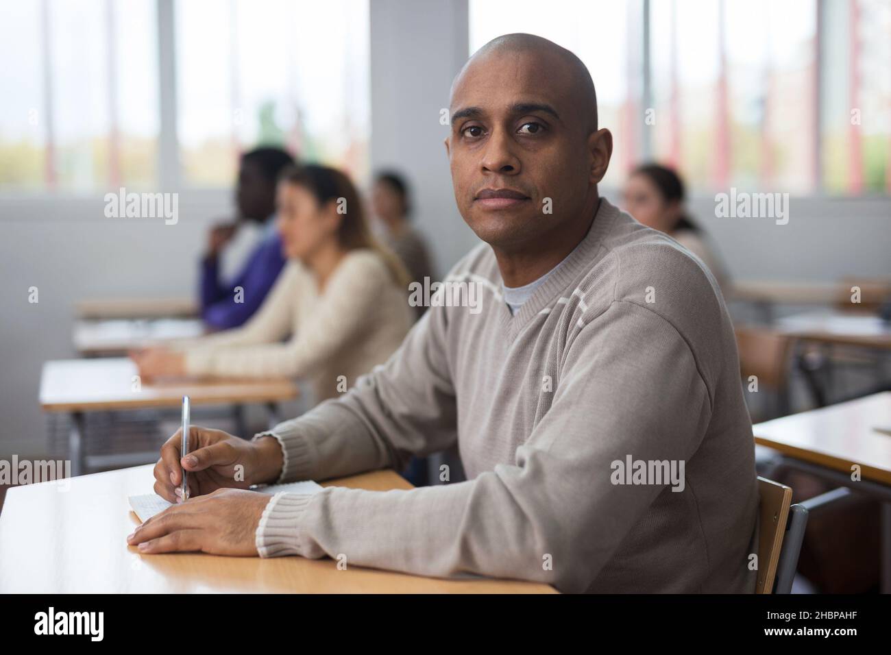 Focused man working at adult education class Stock Photo - Alamy