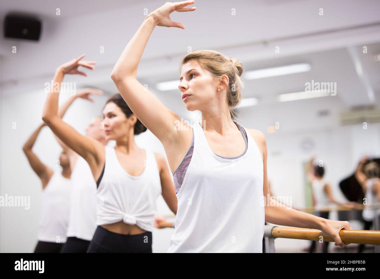 People doing exercises on stretching ballet barre Stock Photo - Alamy